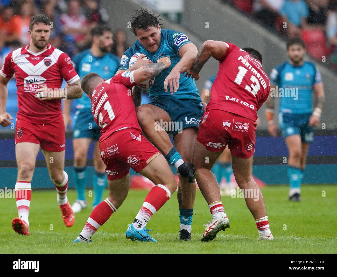 Wigan Warriors' Liam Byrne (centre) is tackled by Salford Red Devils ...