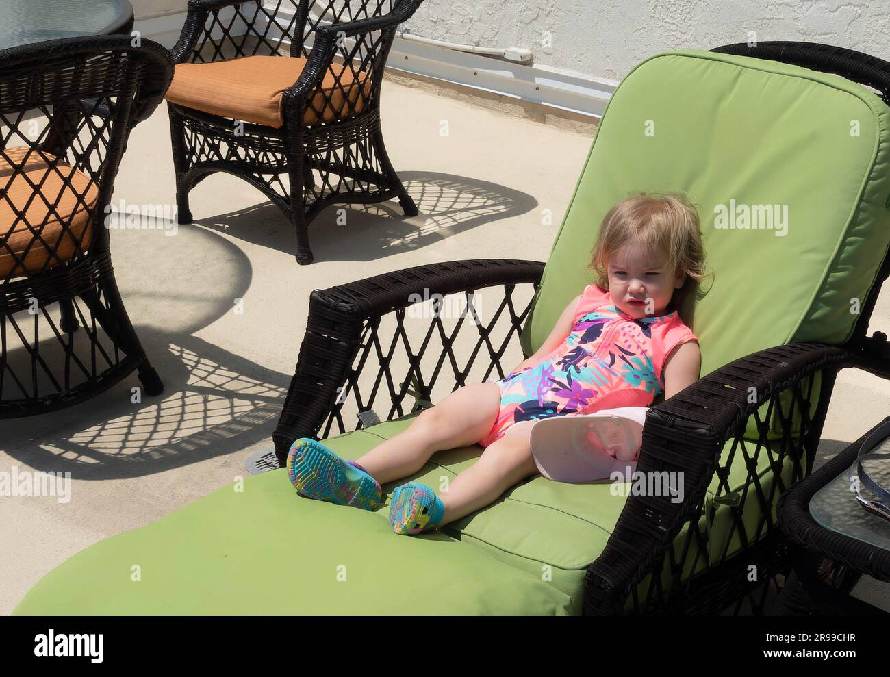 A small child on a patio lounge chair Stock Photo - Alamy