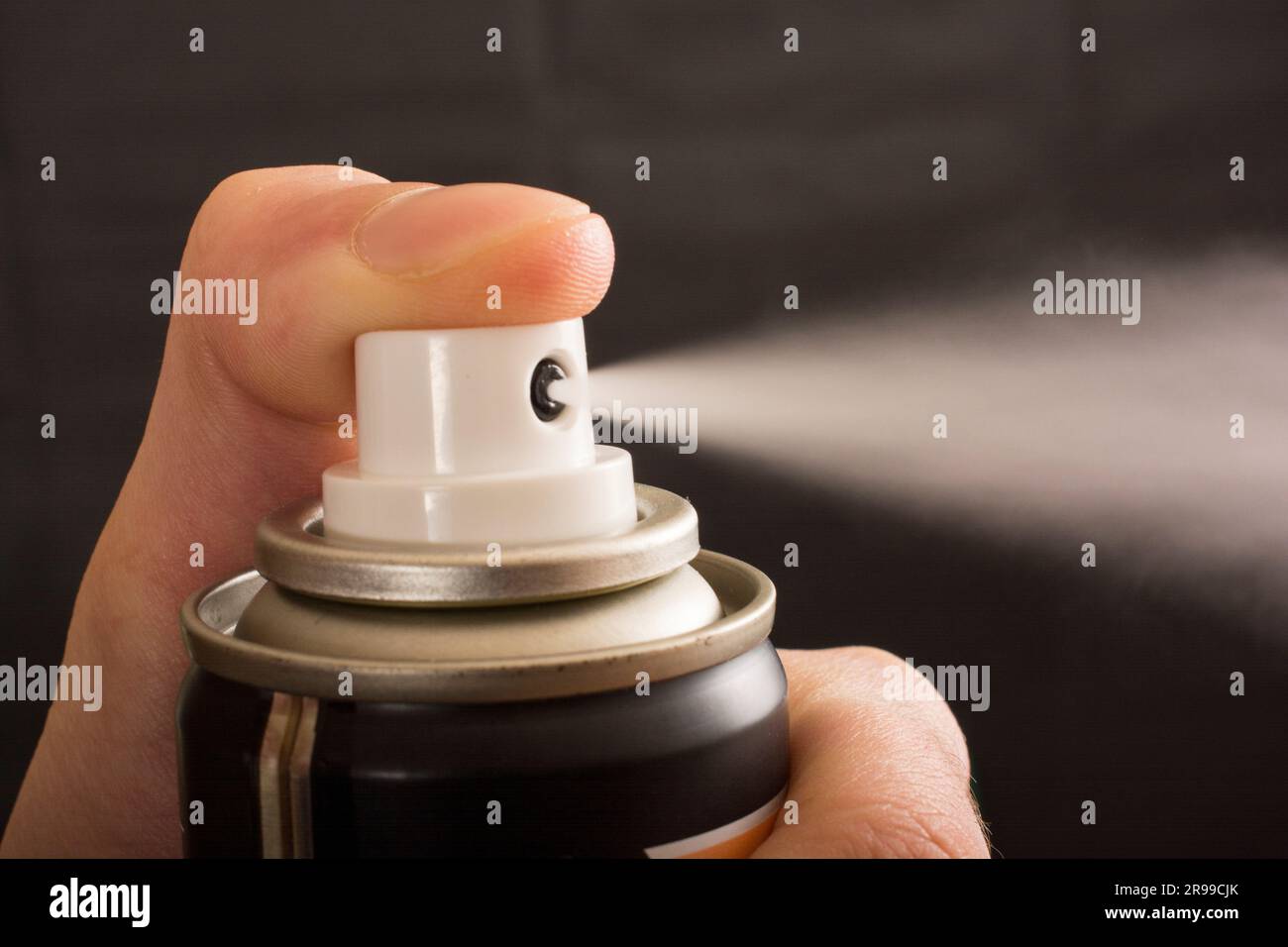 Close-up view of a human hand and pressed bottle of spray isolated on a ...
