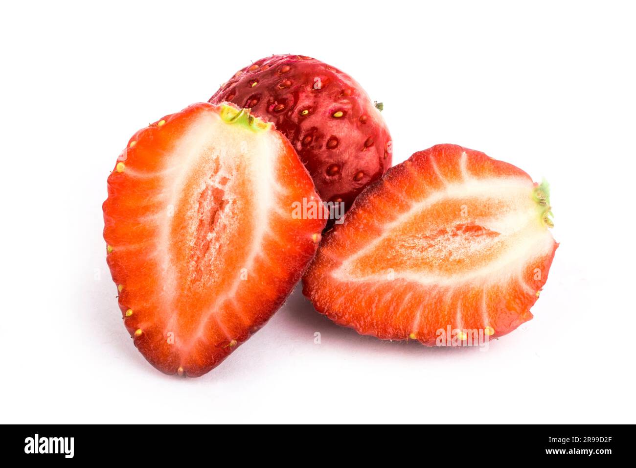 Isolated red strawberries. Three fruits, one cut in half on a white ...