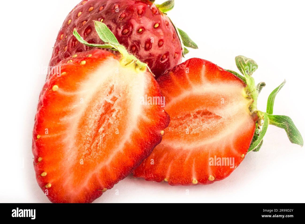 Isolated red strawberries. Three fruits, one cut in half on a white ...