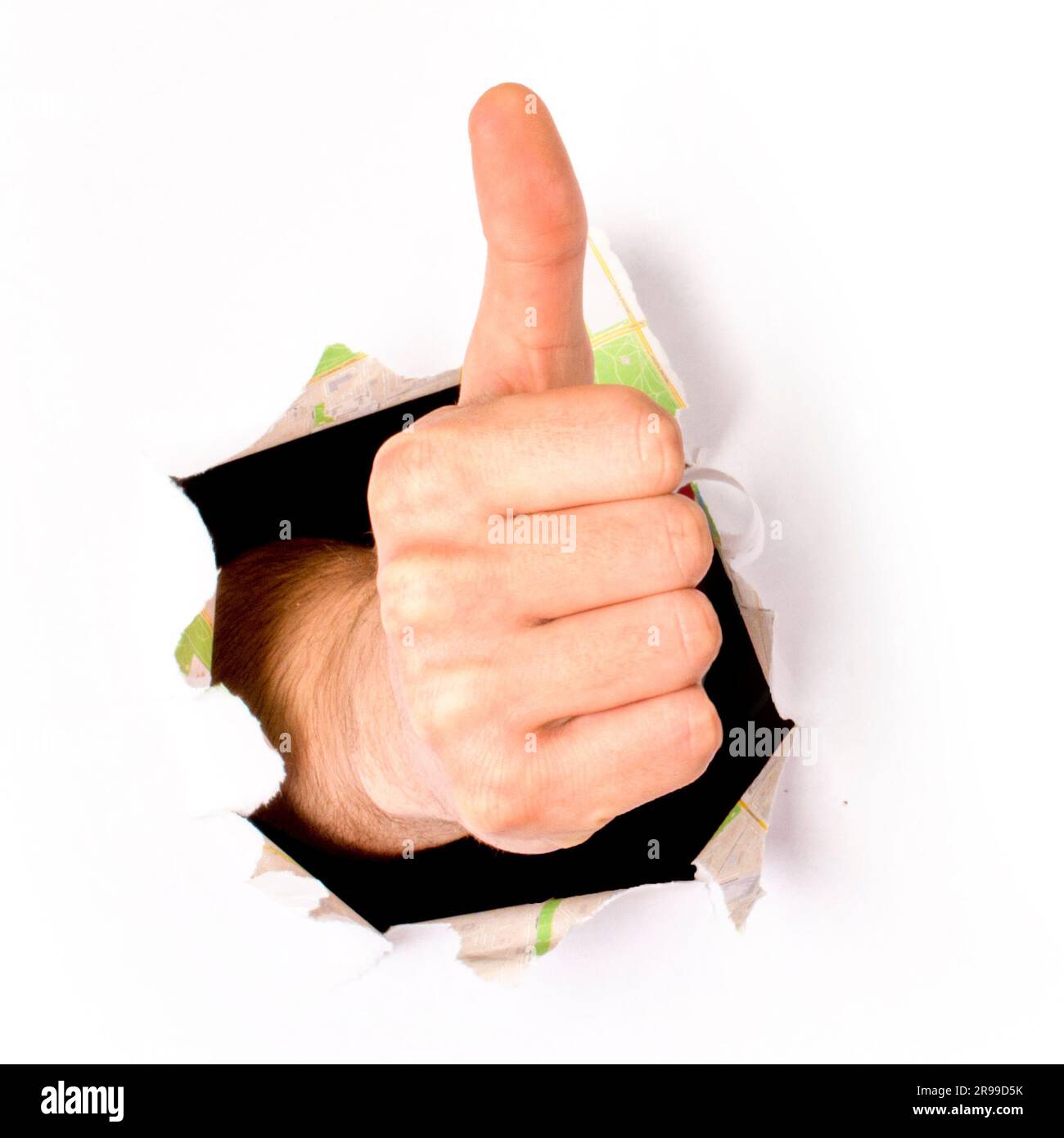 Thumbs up through the paper hole isolated on white background Stock ...