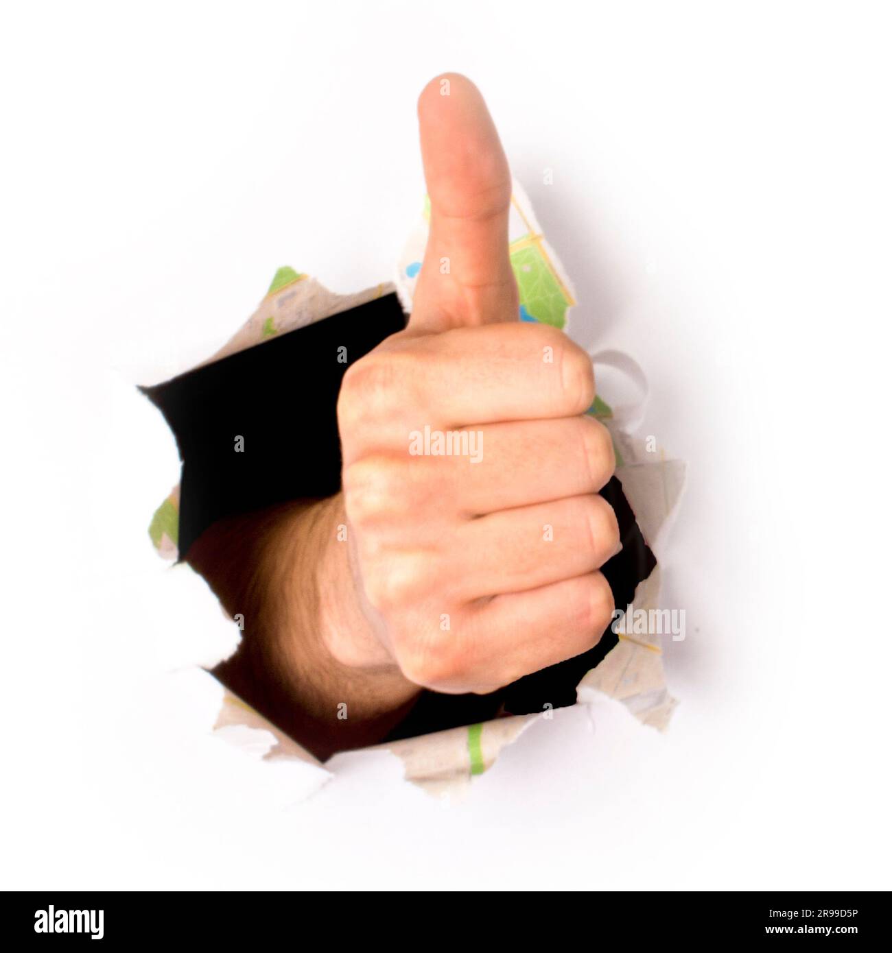 Thumbs up through the paper hole isolated on white background Stock ...