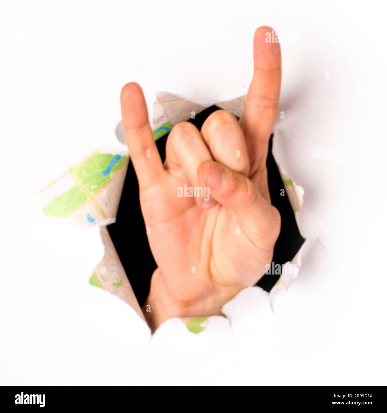 close-up of a hand coming out of a hole in white paper, a rock and roll ...