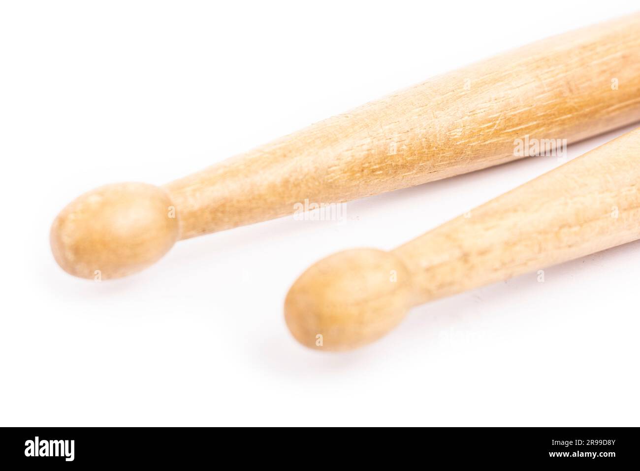 Two wooden drum sticks lying on each other isolated on white background ...