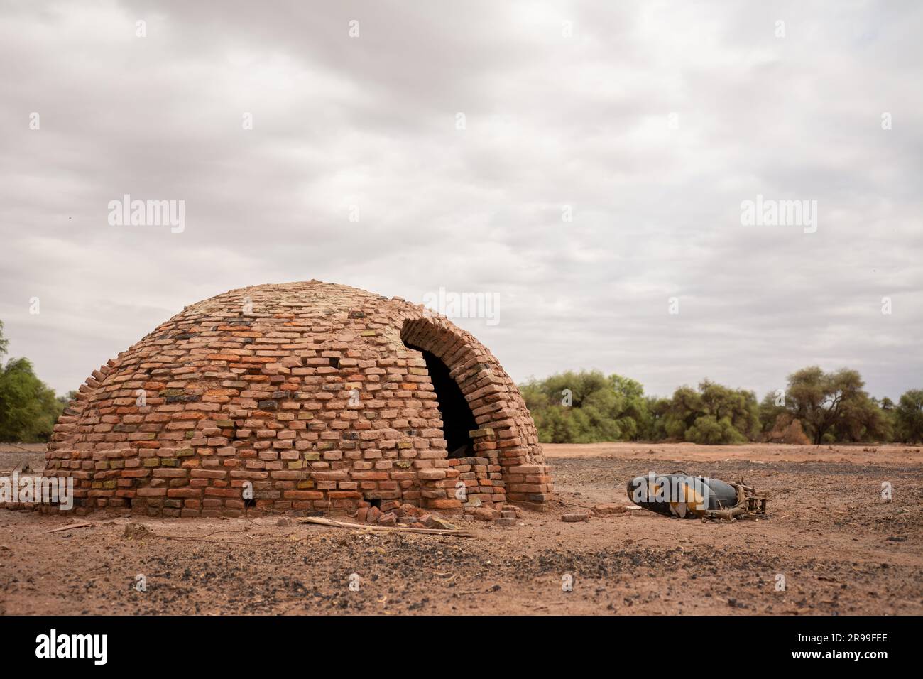 A large, red-brick structure located in a desolate, desert-like ...