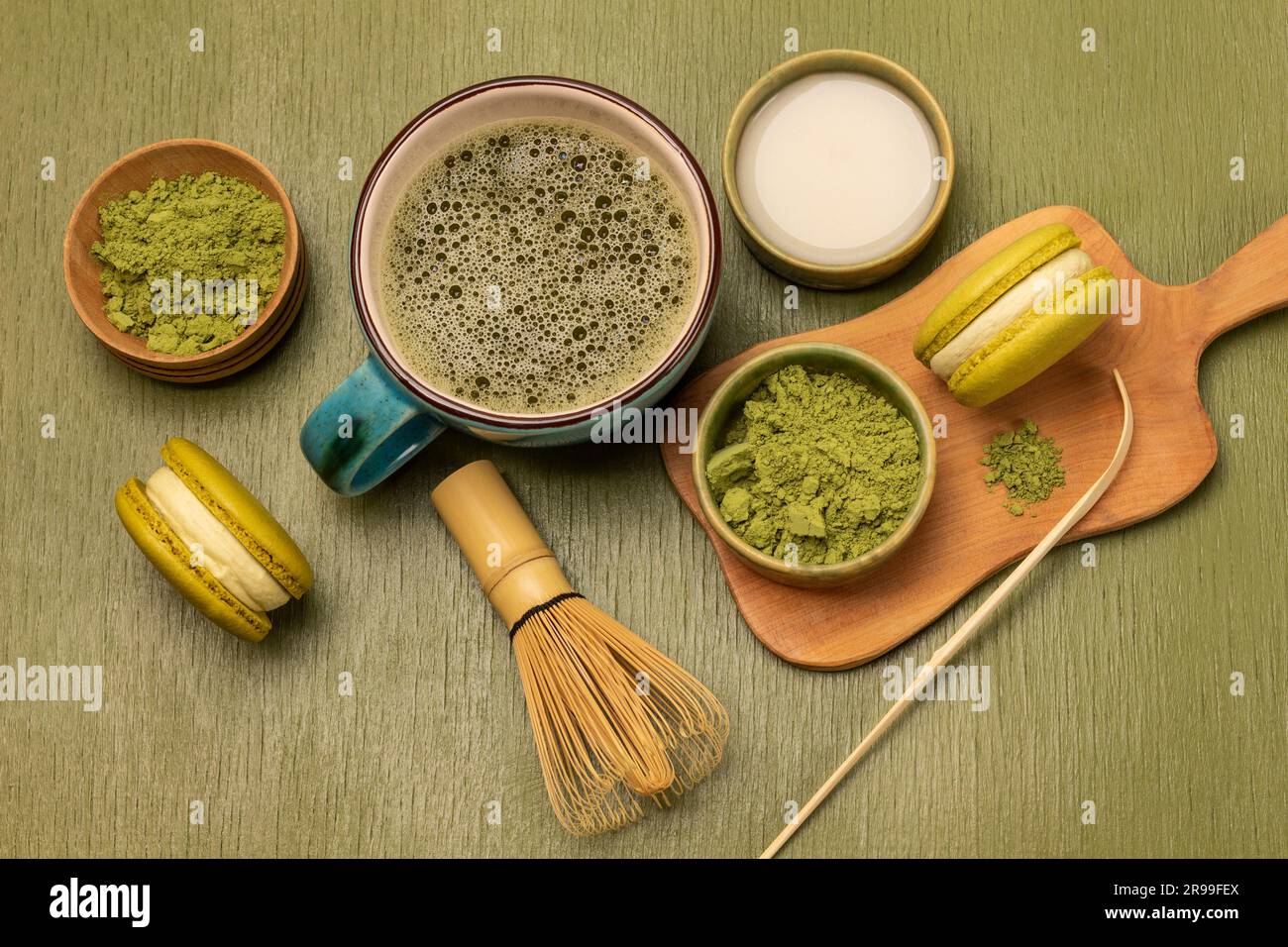Measuring spoon, green matcha powder and macaron biscuits on wooden ...