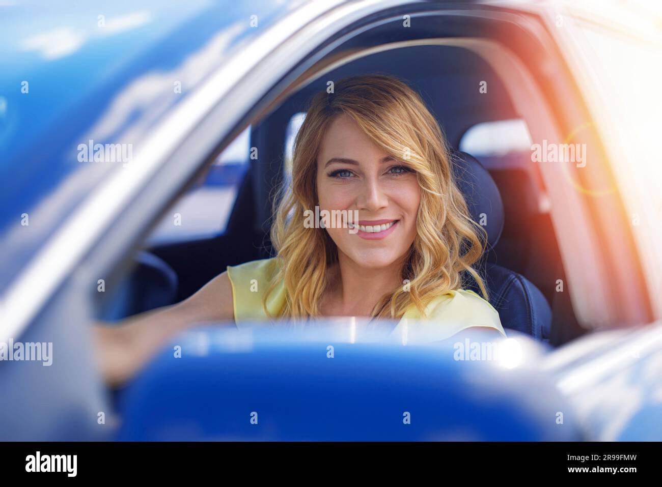 Beautiful blonde woman driving a car Stock Photo - Alamy
