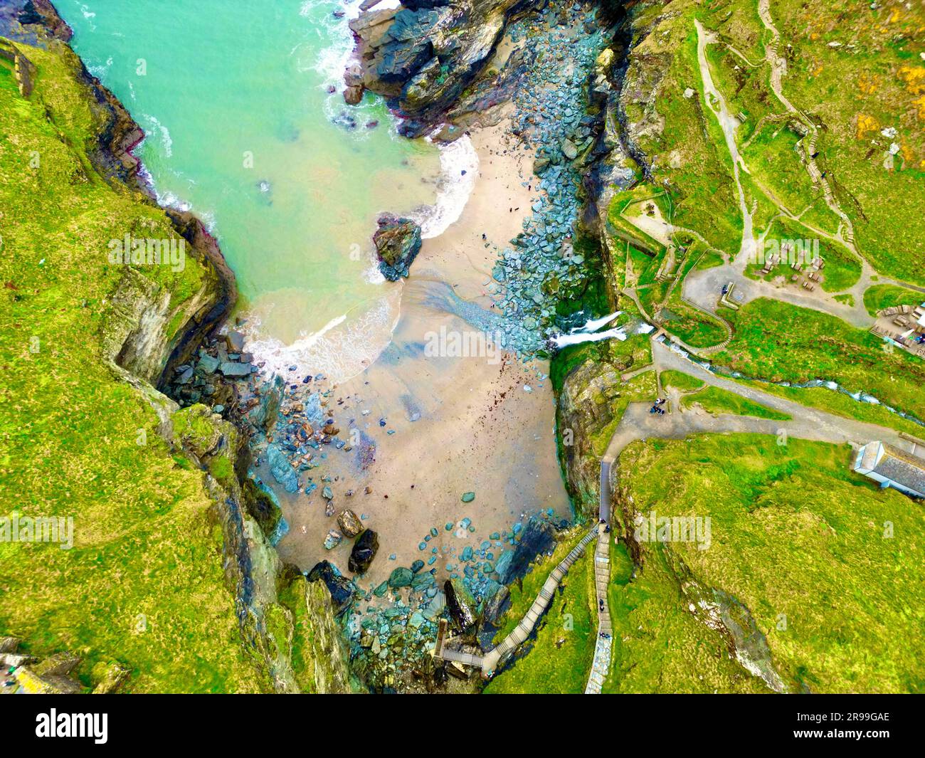 An aerial view of a coastal landscape, featuring bright green shoreline ...