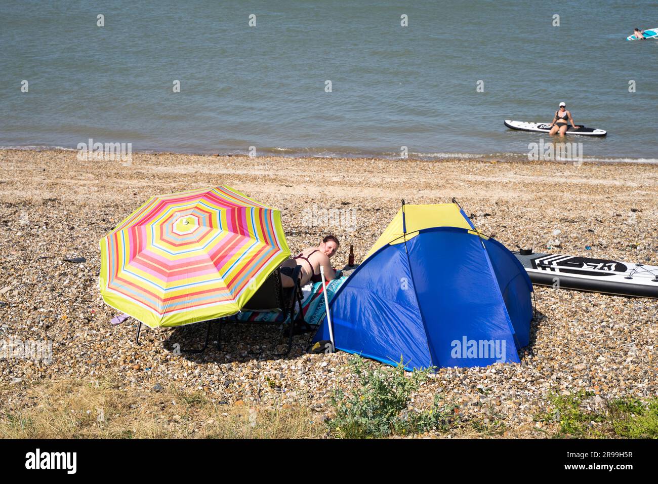 Kent, 25th June 2023. UK Weather. Beach goers resting under umbrella ...