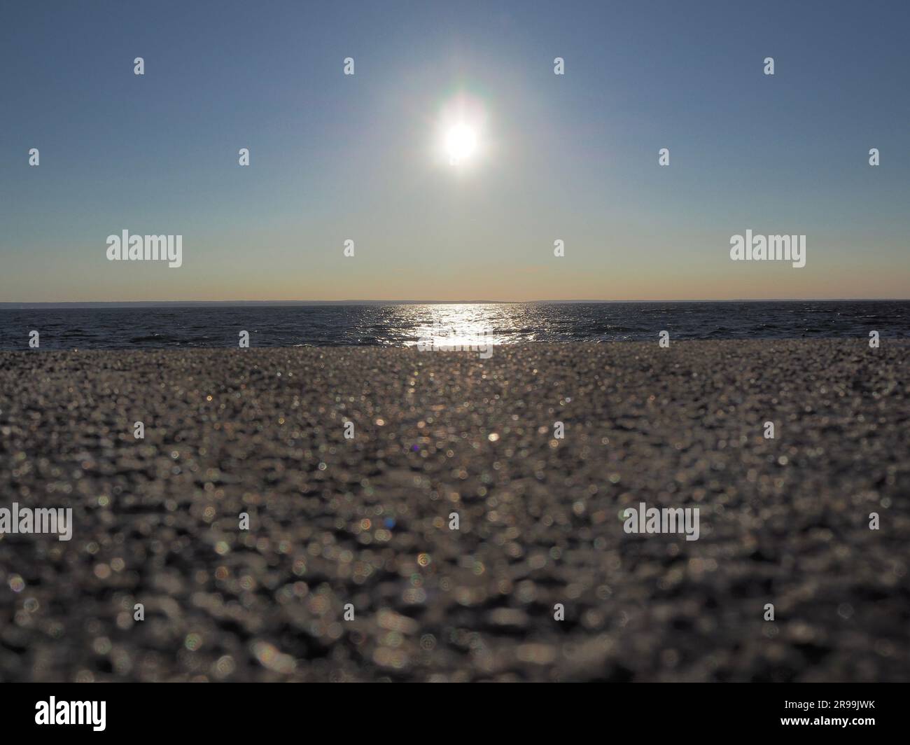 The sun seen over the concrete structures in the harbour with ...