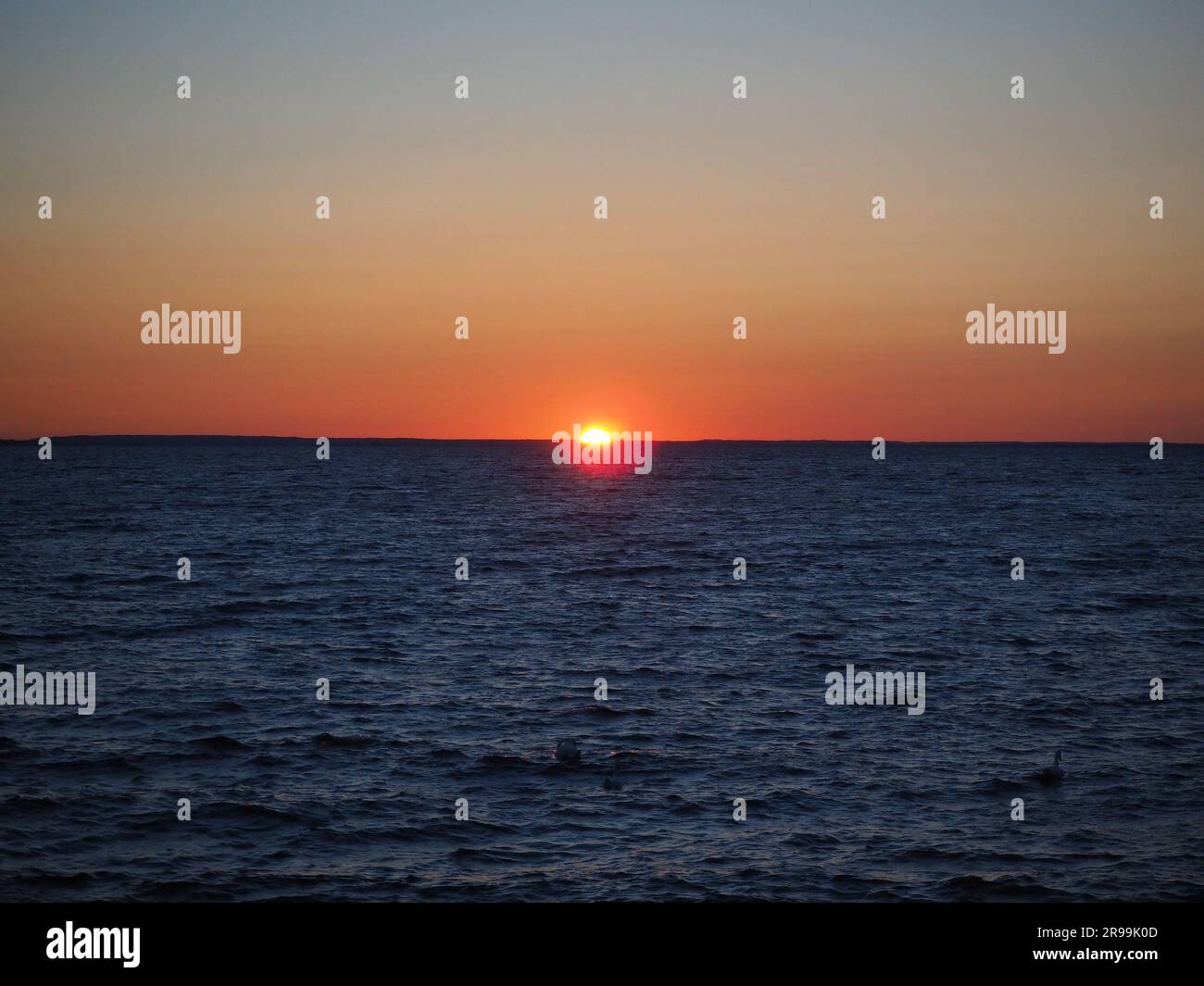 Sunset photo showing the sun slowly falling below the surface of the ...