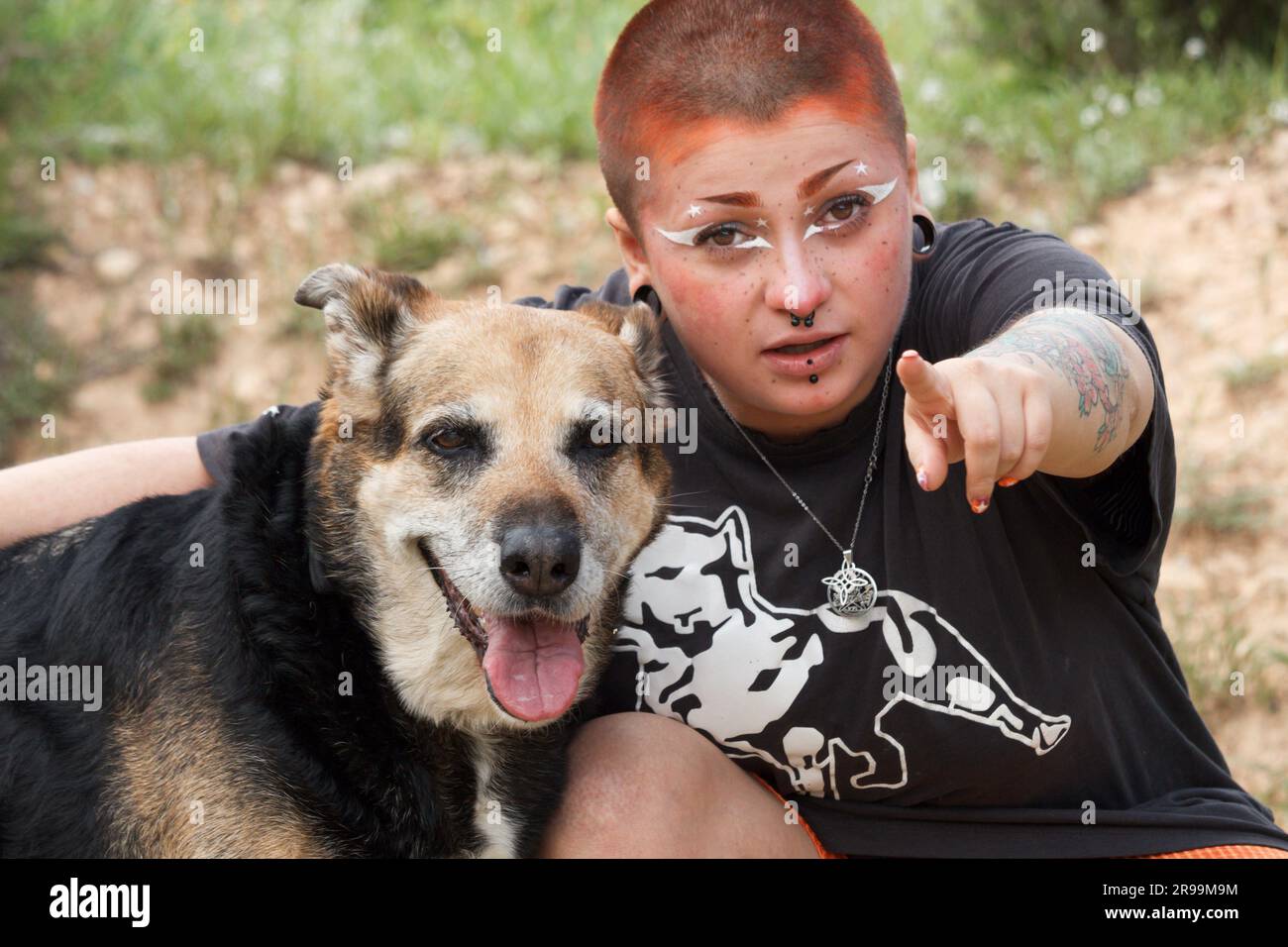 Woman in makeup next to adult dog pointing and looking at camera Stock ...