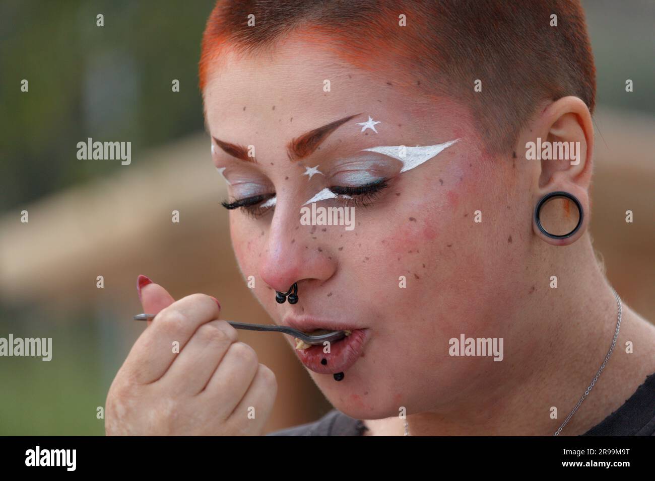Young woman with fantasy makeup and dermatitis performing the action of ...