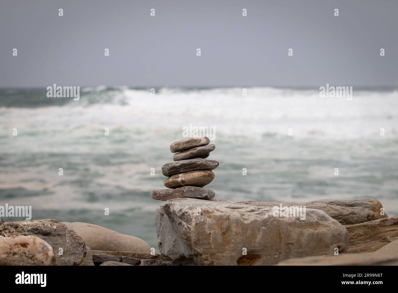 A scenic coastal landscape featuring a pile of rocks stacked atop ...