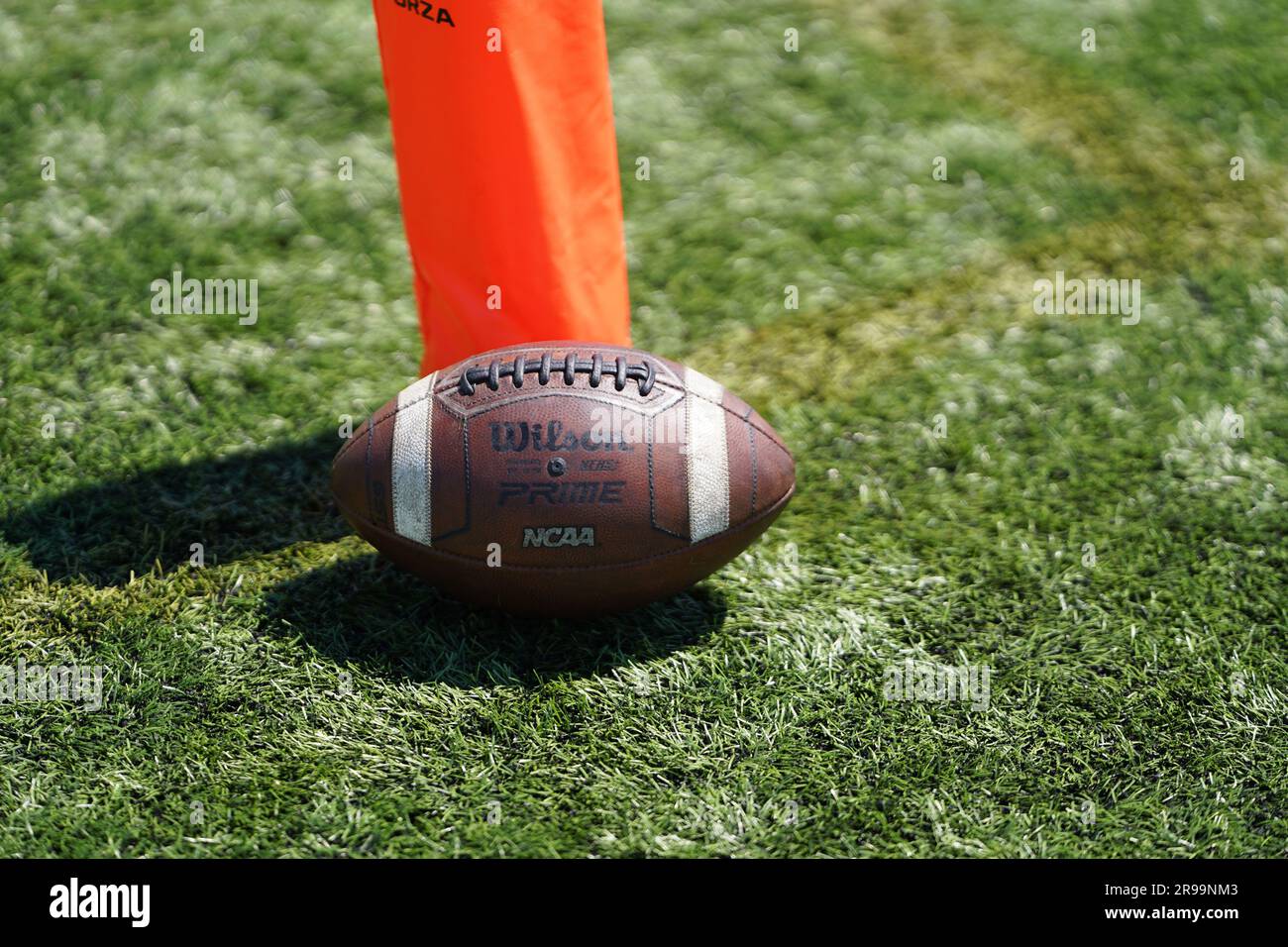 Wilson American Footballs next to an Orange Corner Pylon on an ...