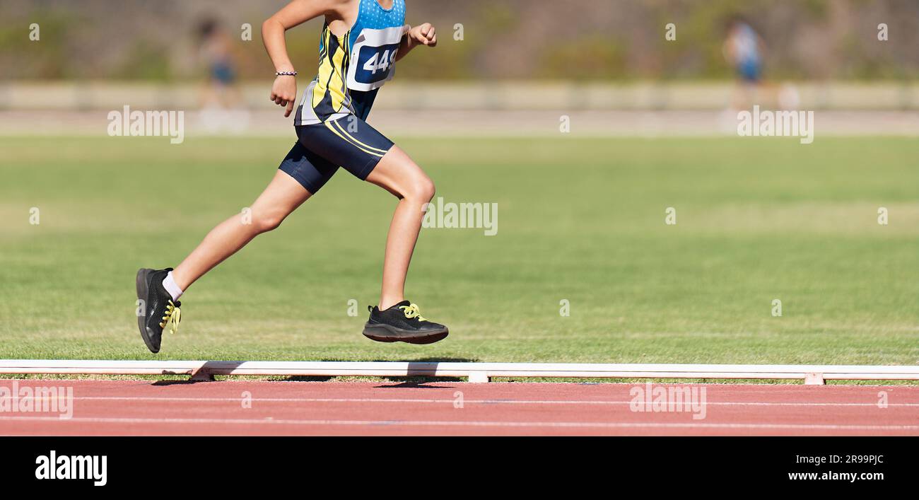 Child running in stadium. Kids run on outdoor track. Young athlete ...