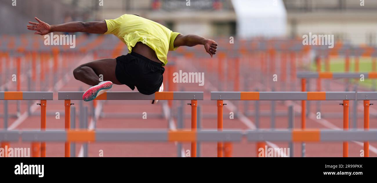 A hurdle runner leaping over the hurdles, man is jumping over the ...