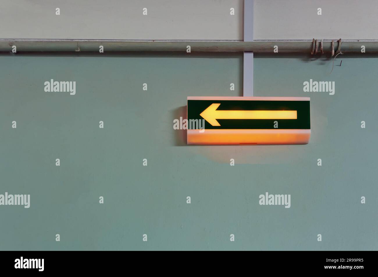 Emergency exit sign in a building glowing yellow Stock Photo - Alamy