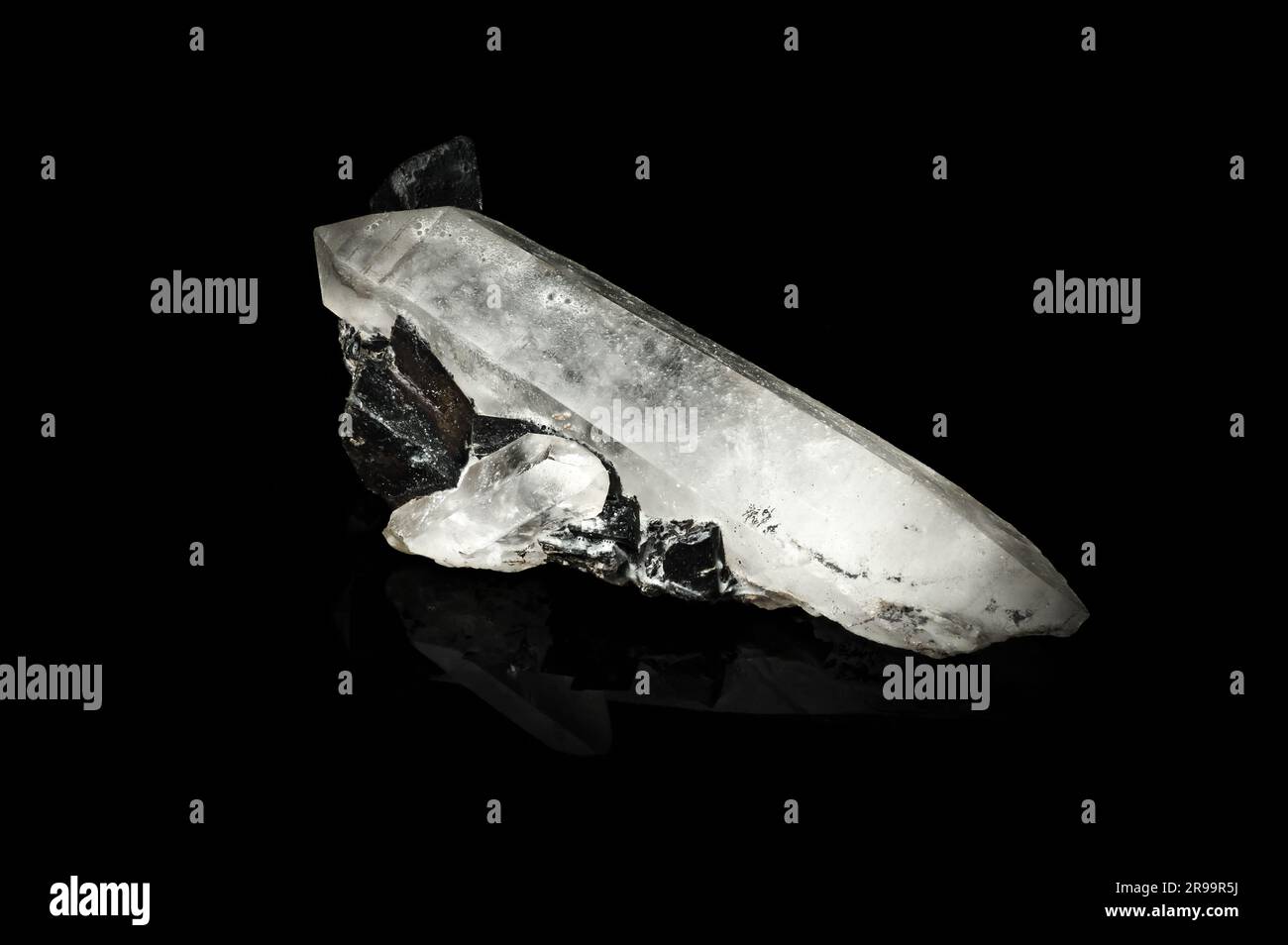 quartz crystal rod with magnetite isolated on black background. macro ...