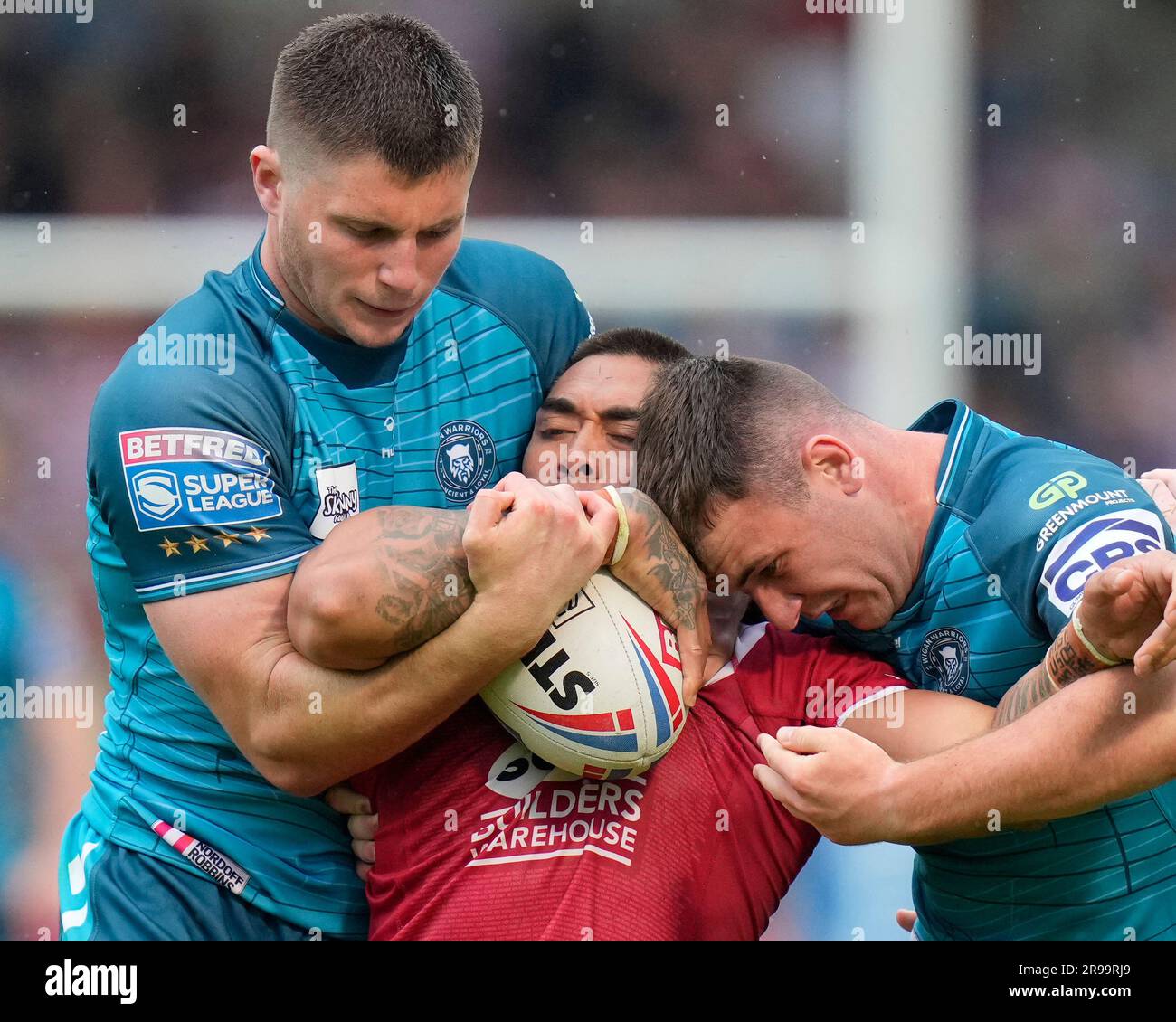 Ken Sio #2 of Salford Red Devils is held by Ethan Havard #16 of Wigan ...