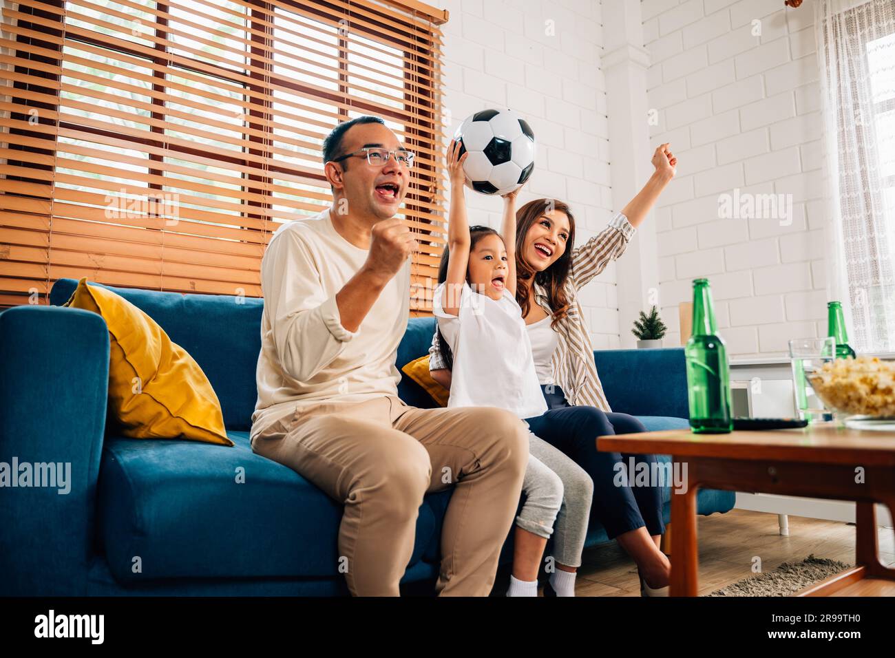 Happy family watching sports match together on television Stock Photo ...