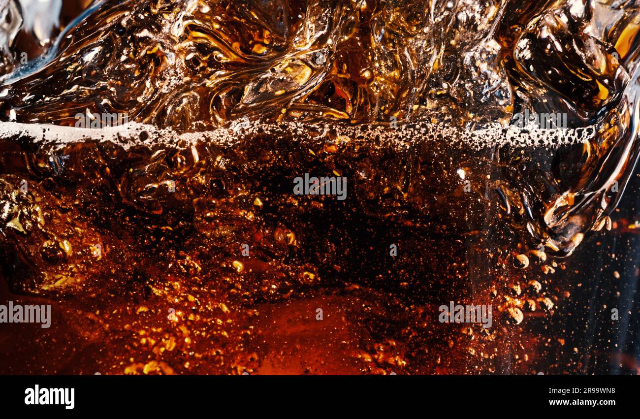 Cola with Ice. Close up of the ice cubes in cola water. Texture of carbonate drink with bubbles ...