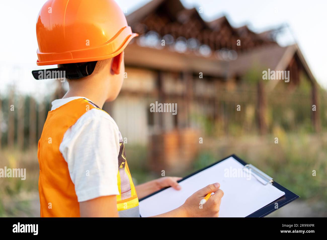 Child in a suit of an engineer is checking and inspecting the building ...