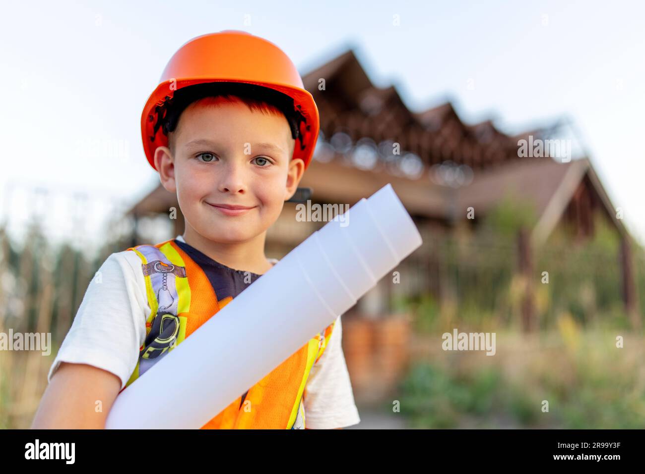 A child in an engineer suit with a yellow helmet with blueprints Stock ...