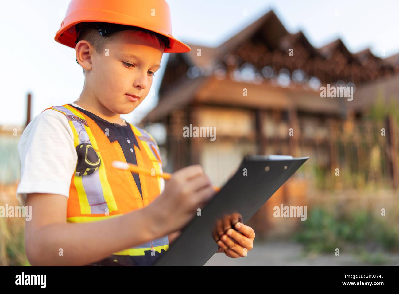 Child in a suit of an engineer is checking and inspecting the building ...
