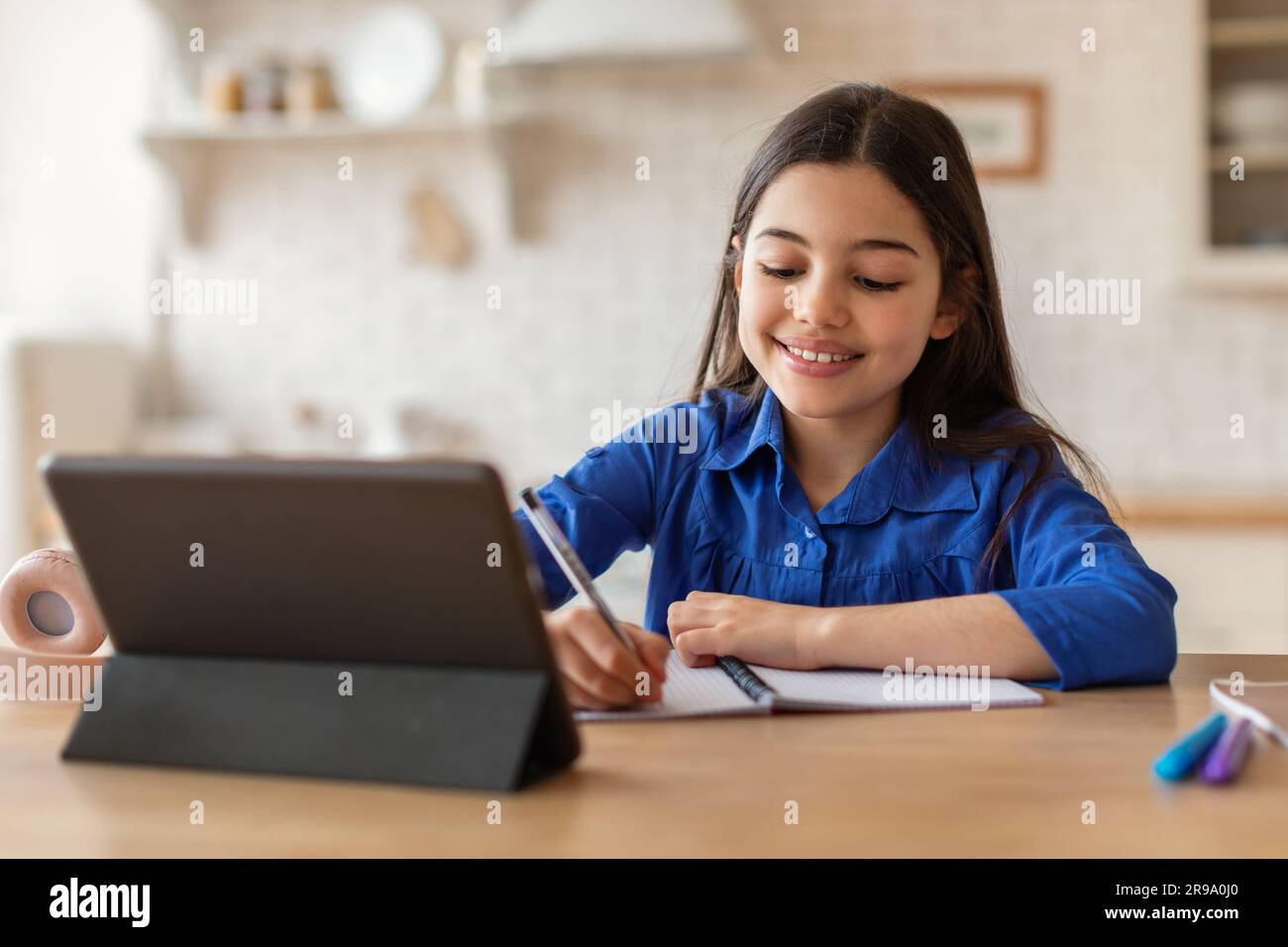 School kid girl learning at tablet taking notes at home Stock Photo - Alamy