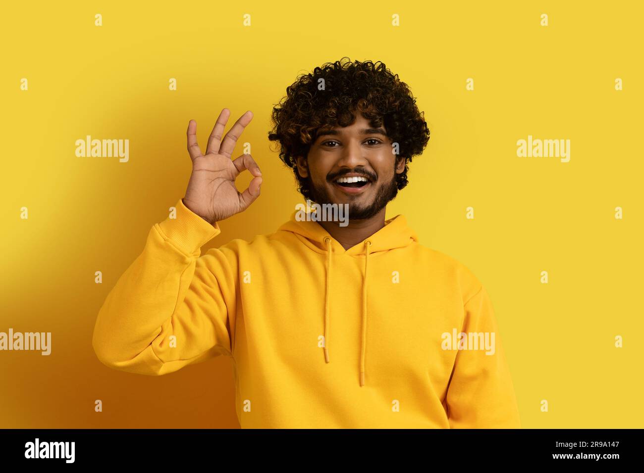 Positive cool indian guy showing okay gesture and smiling Stock Photo ...