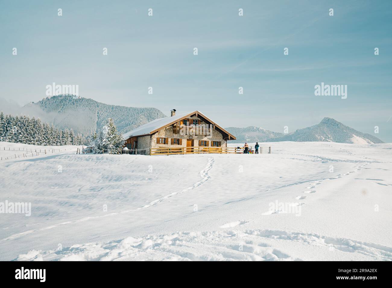 A scenic snow-covered landscape featuring a small log cabin in the ...