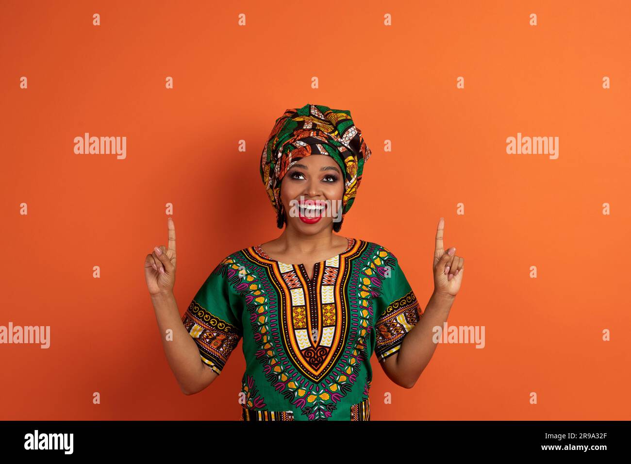 Emotional african lady pointing up at copy space Stock Photo - Alamy