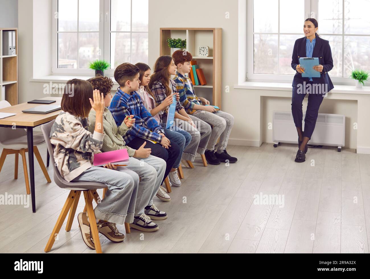 Group of elementary school students and their teacher having a class in ...