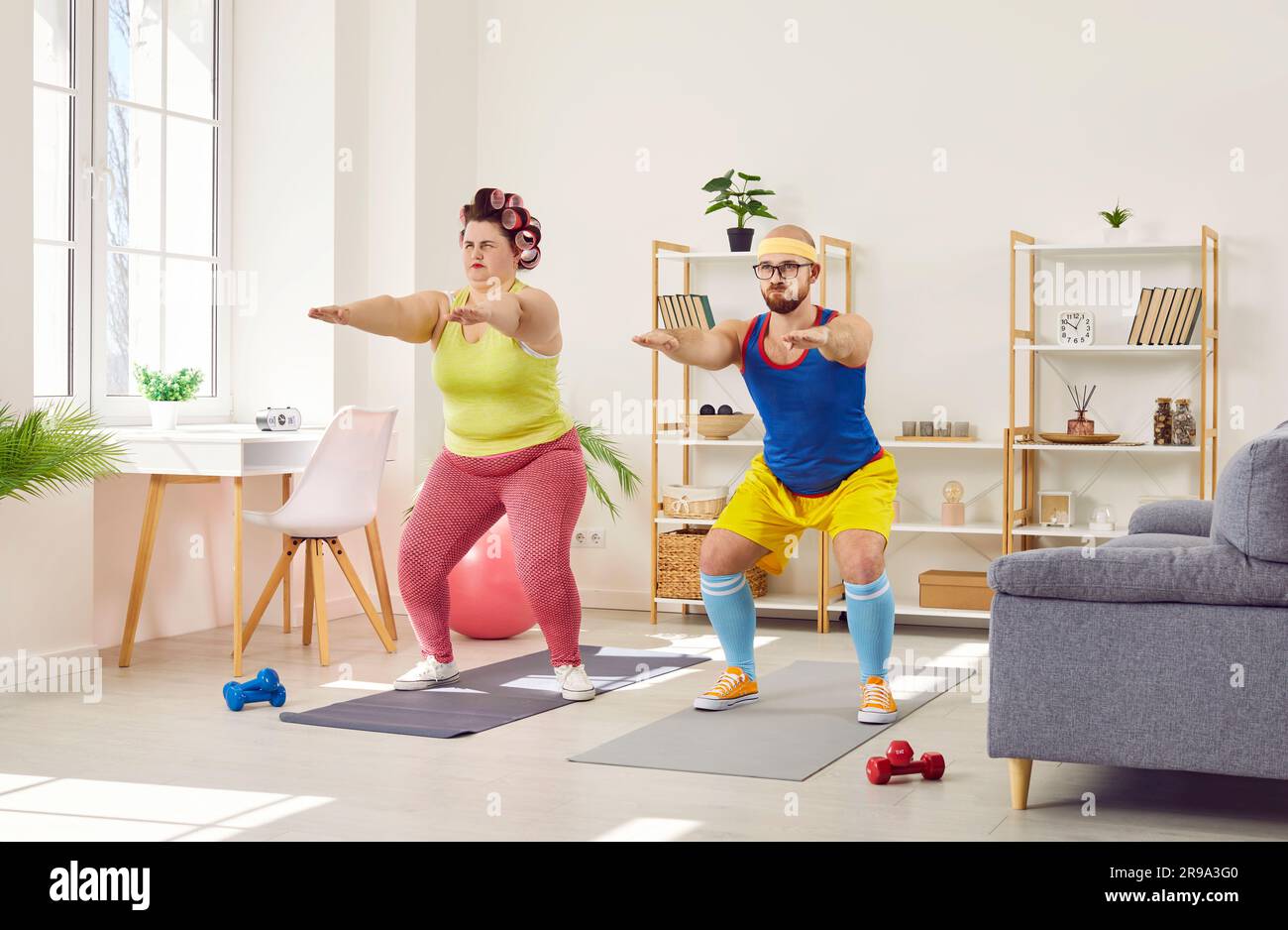 Funny plump woman doing squats with her personal trainer Stock Photo ...
