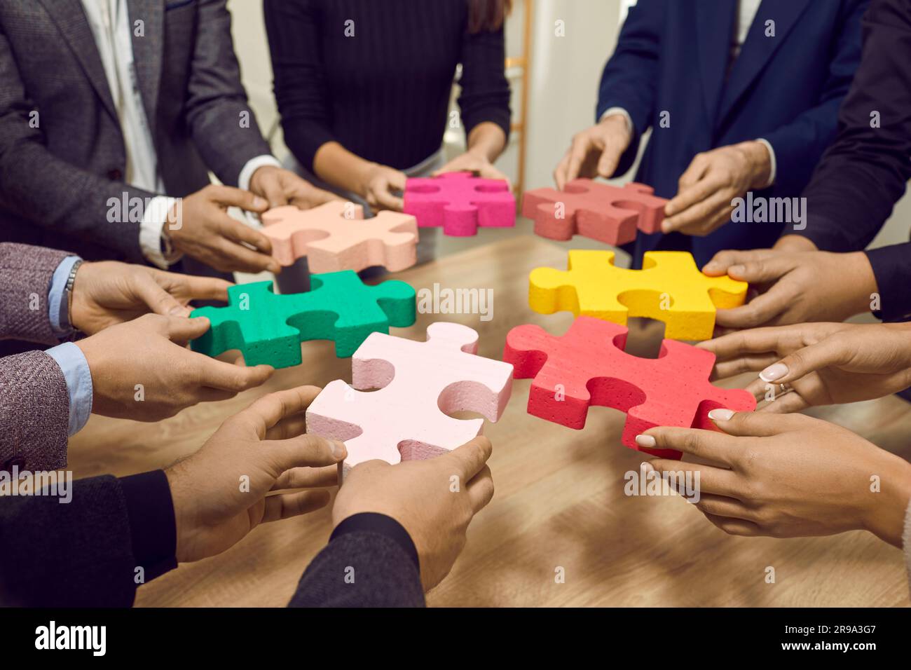 Different business people connect together large pieces of colored ...