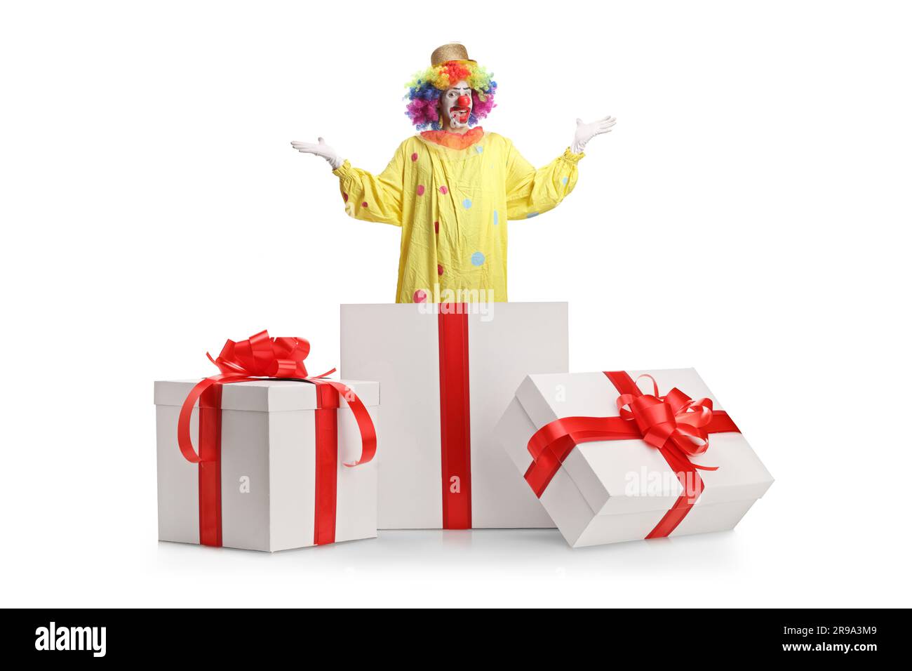 Clown inside a present box performing a surprise isolated on white ...