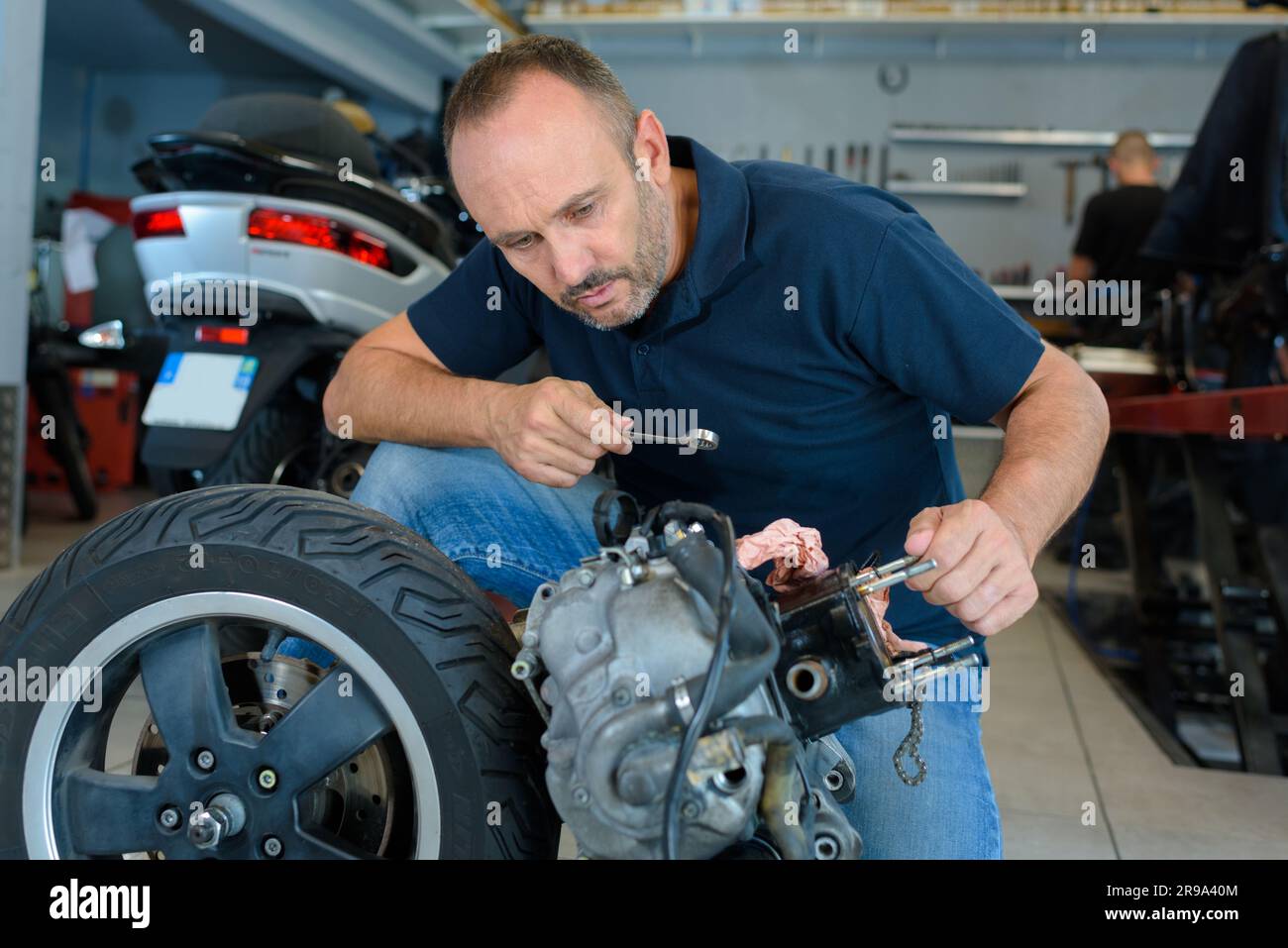 a man fixing a motorcycle in garage Stock Photo - Alamy