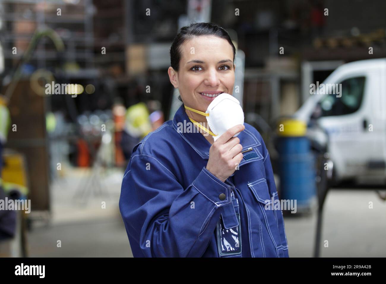 female factory worker holding dust mask by her face Stock Photo - Alamy