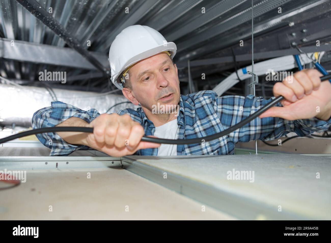 man fixing wires on the ceiling Stock Photo - Alamy