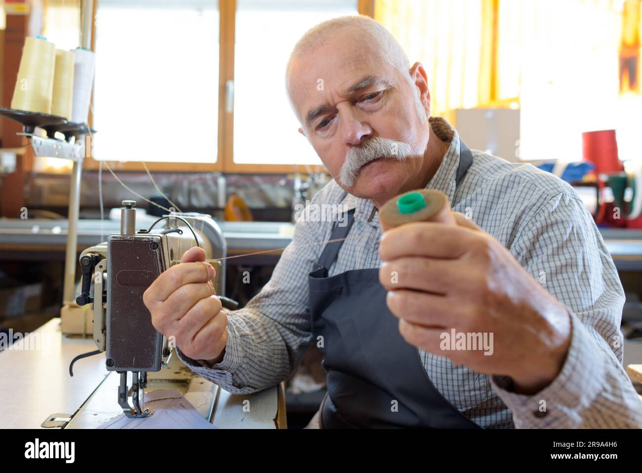 senior man threading old fashioned manual sewing machine Stock Photo ...