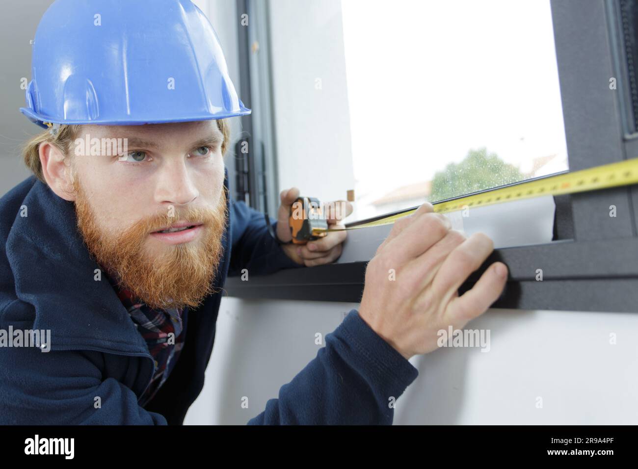 service man measuring window for installation indoors Stock Photo - Alamy