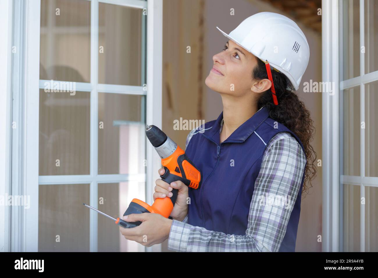 female window builder working on mount of new installation Stock Photo ...