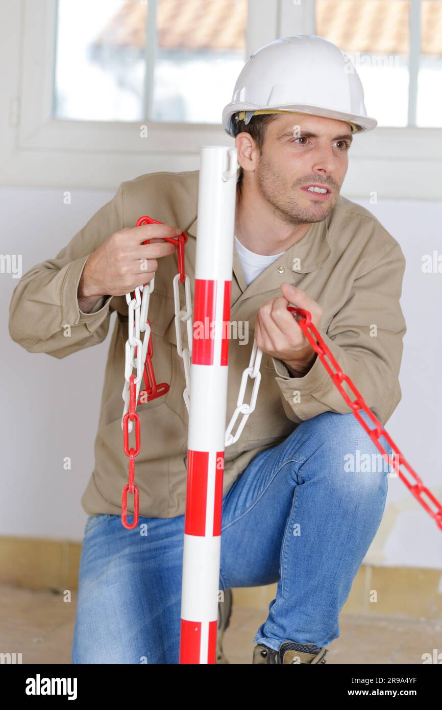 workman setting up barrier in indoor site Stock Photo - Alamy
