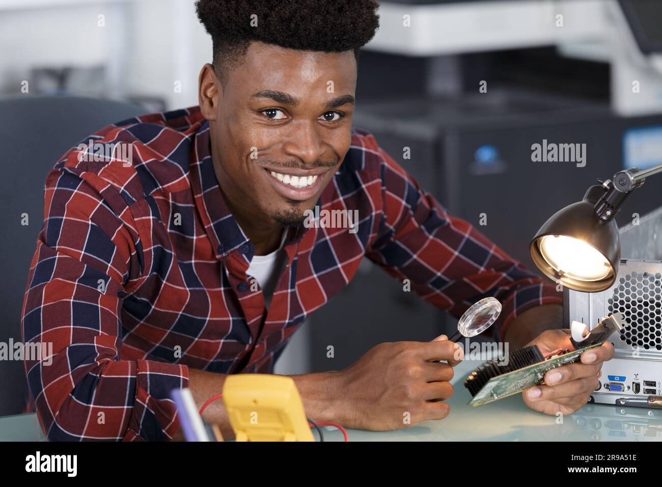 computer technician using magnifying glass and inspection lamp Stock ...
