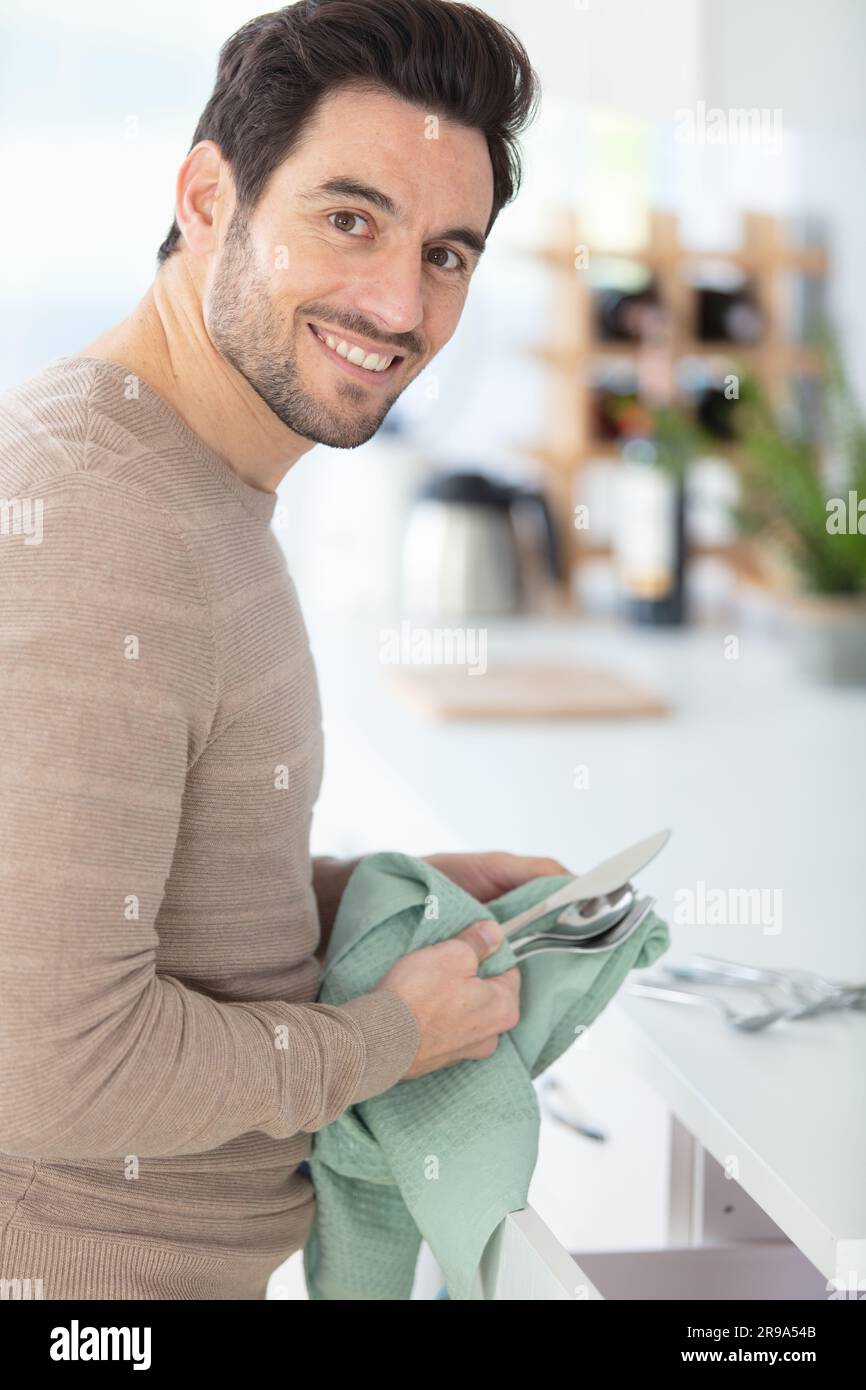 young man washing and drying the dishes at home Stock Photo - Alamy