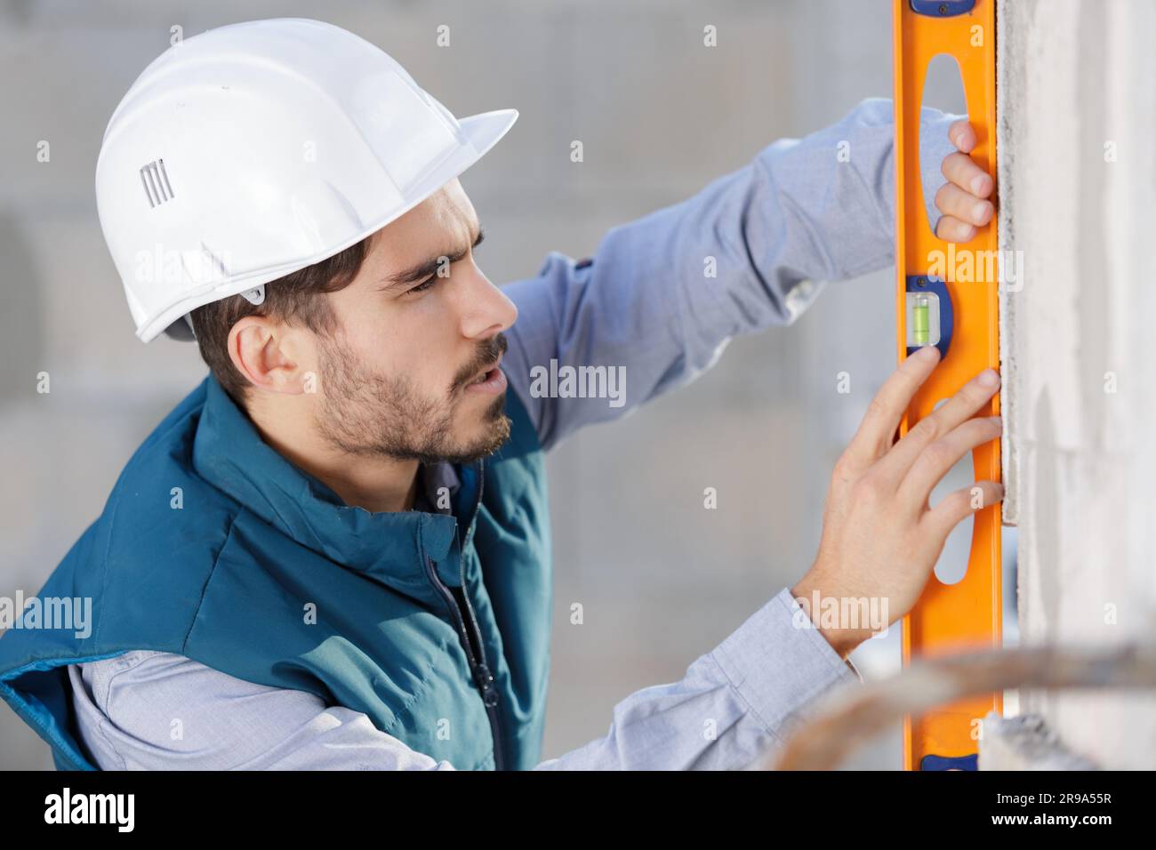 man builder measuring the level of a wall Stock Photo - Alamy