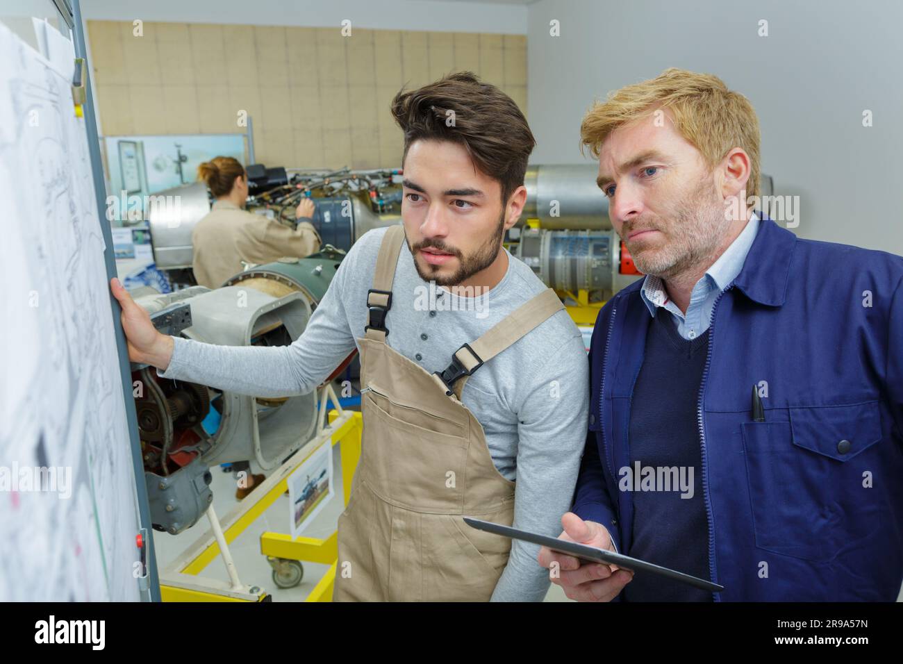 two young creative engineers working on drawing board Stock Photo - Alamy