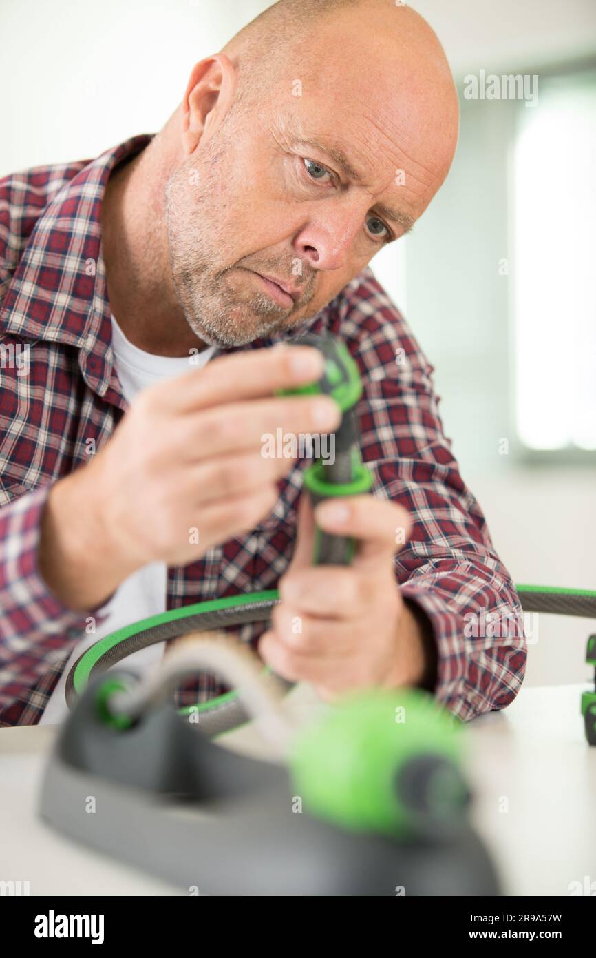 balding man assembling a garden hose Stock Photo - Alamy